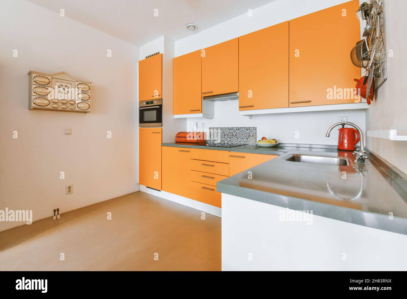 Stylish kitchen design with orange kitchen set Stock Photo - Alamy