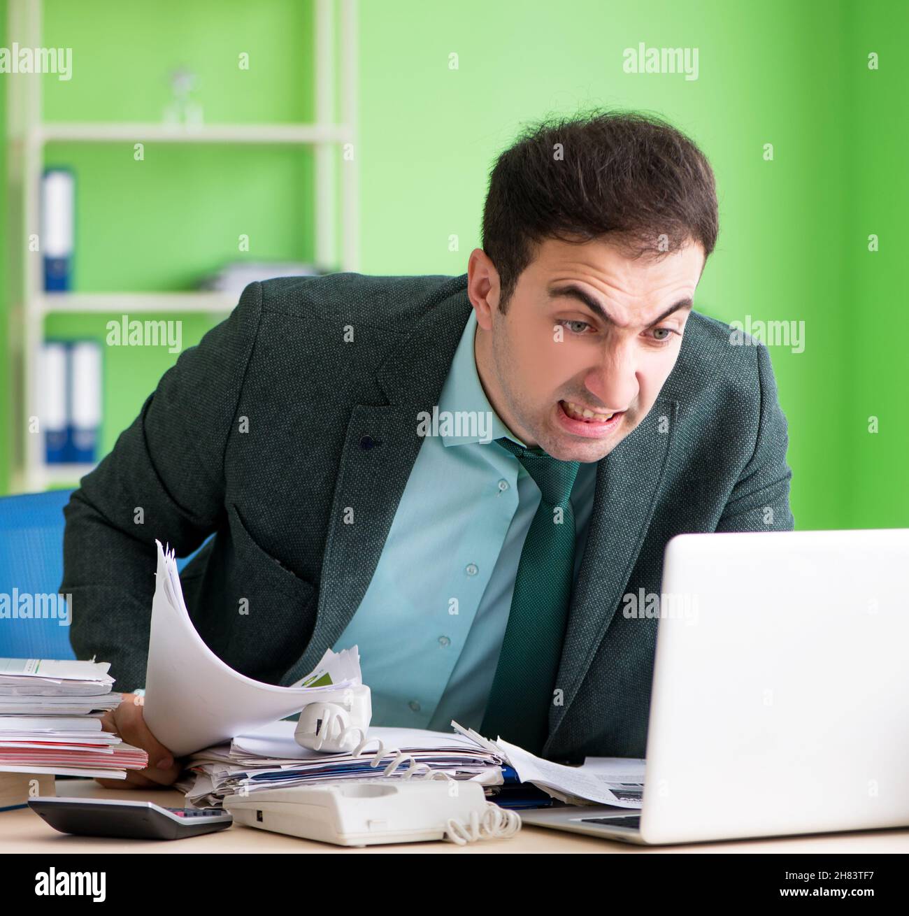 The businessman angry with excessive work sitting in the office Stock ...