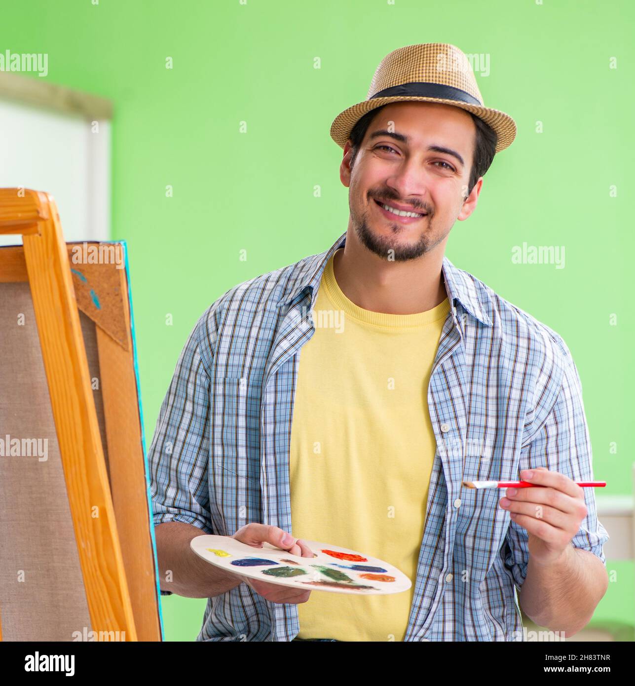 The young male artist working on new painting in his studio Stock Photo ...