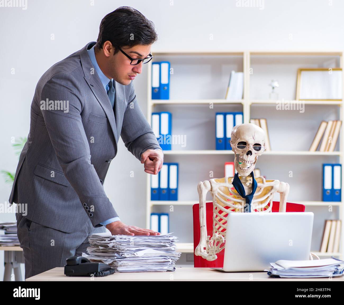 The angry boss yelling at his skeleton employee Stock Photo - Alamy