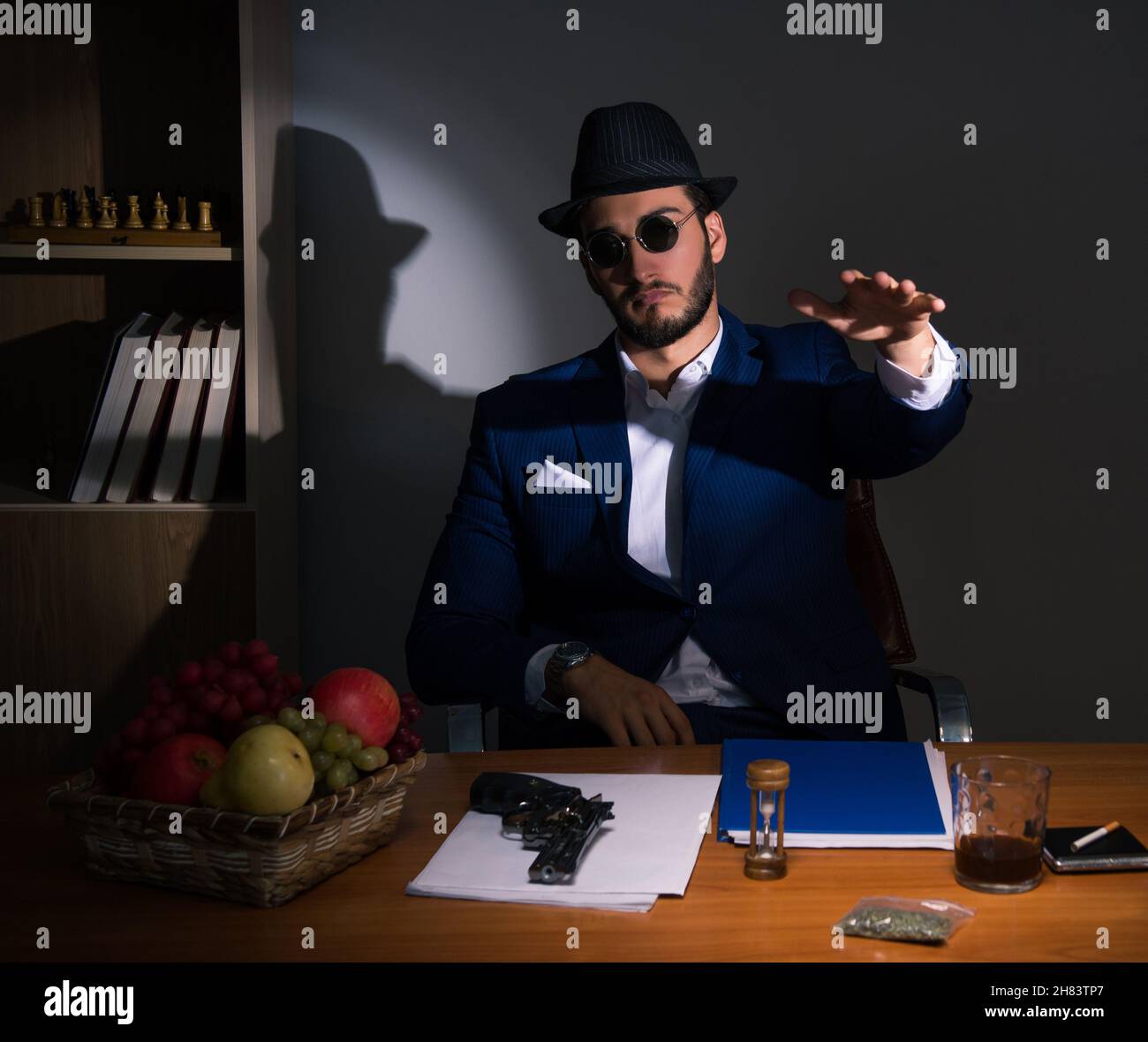 The detective sitting in dark room in vintage concept Stock Photo - Alamy