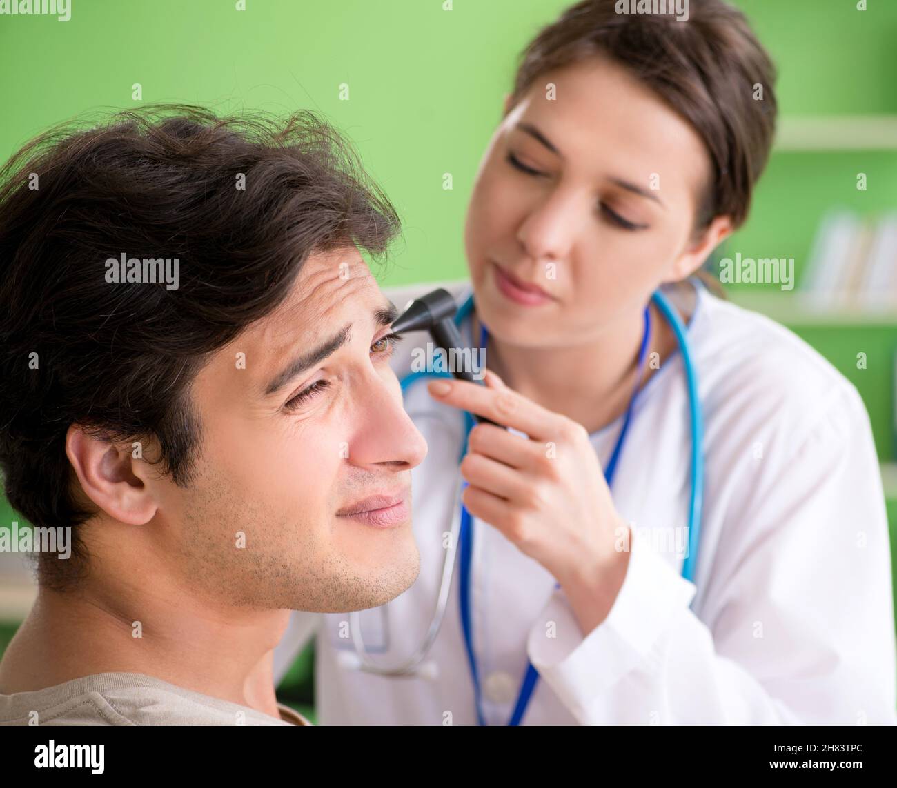 The female doctor checking patient's ear during medical examination ...