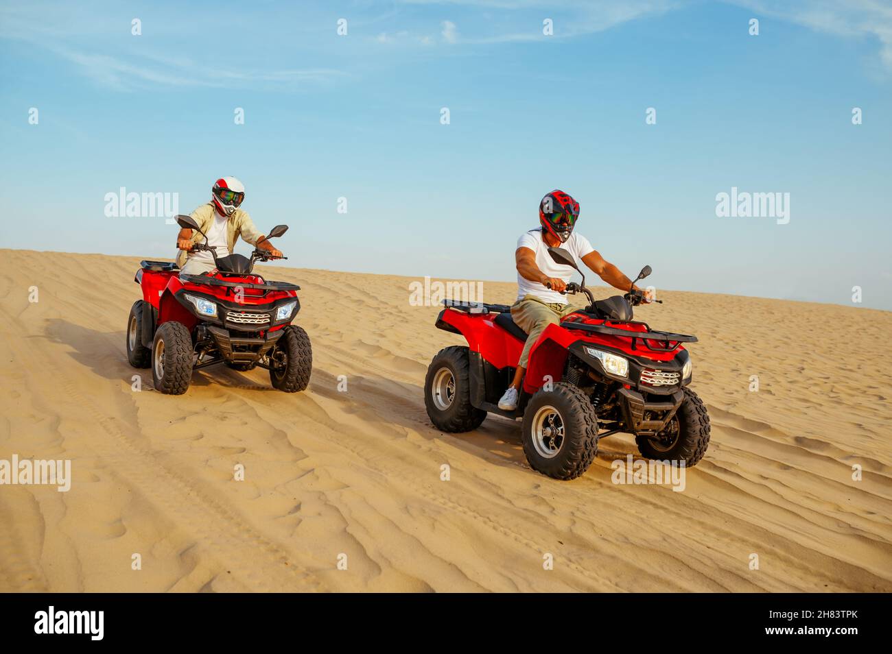 Two racers coming down from the dunes on atv Stock Photo - Alamy