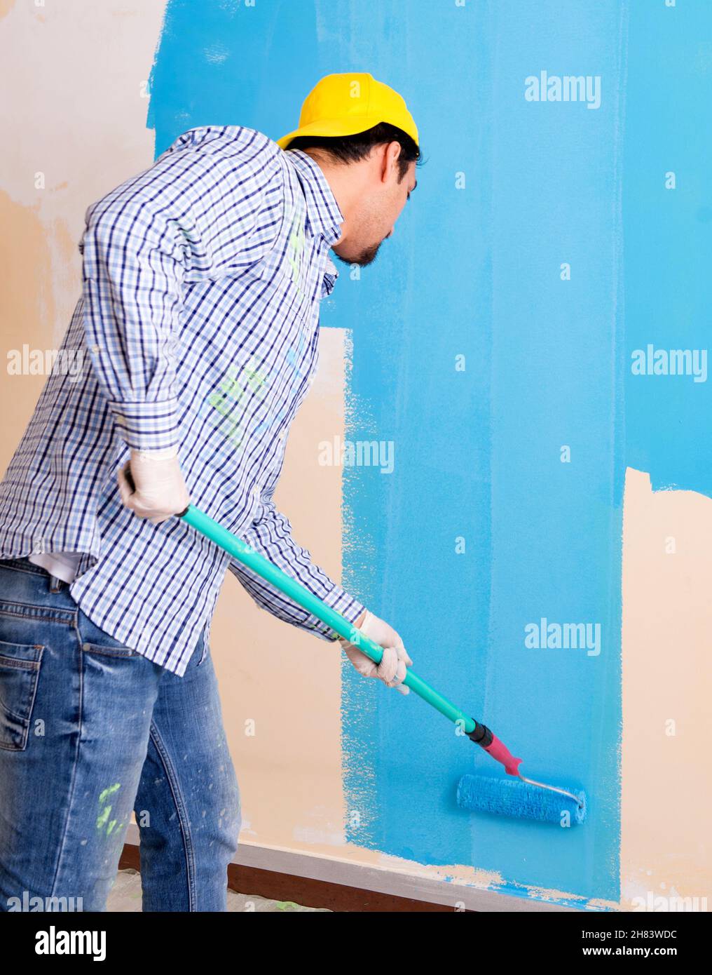 The painter man painting the wall at home Stock Photo - Alamy