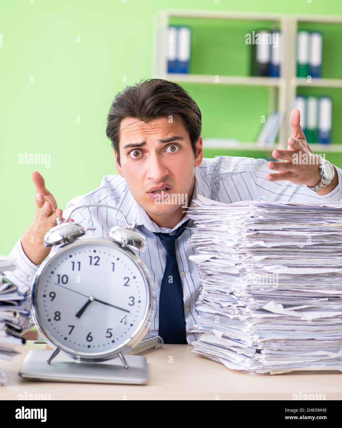 The businessman having problems with paperwork and workload Stock Photo ...