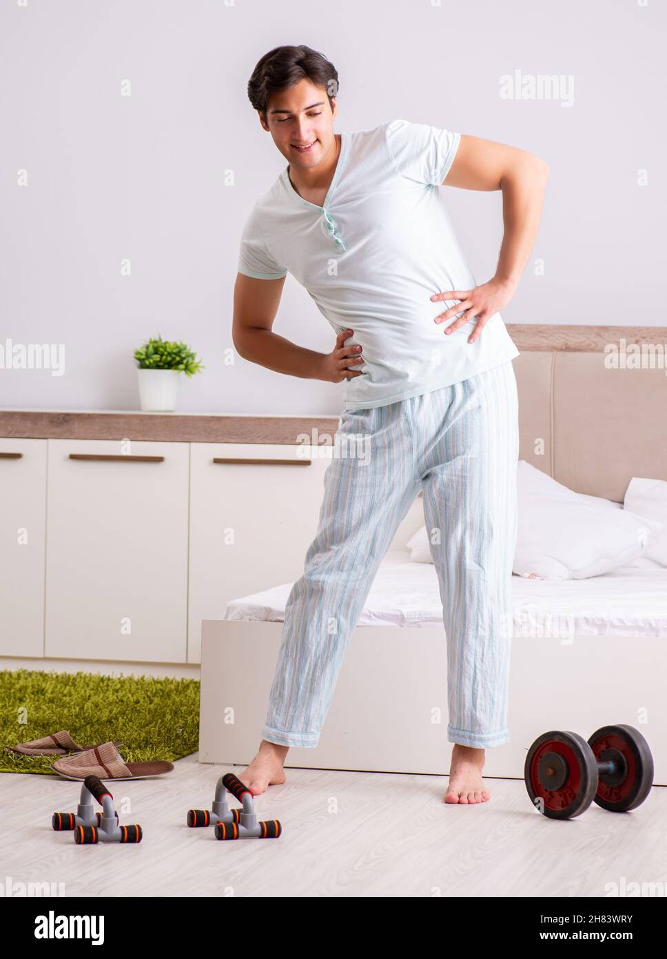 The young man doing morning routine in bedroom Stock Photo - Alamy