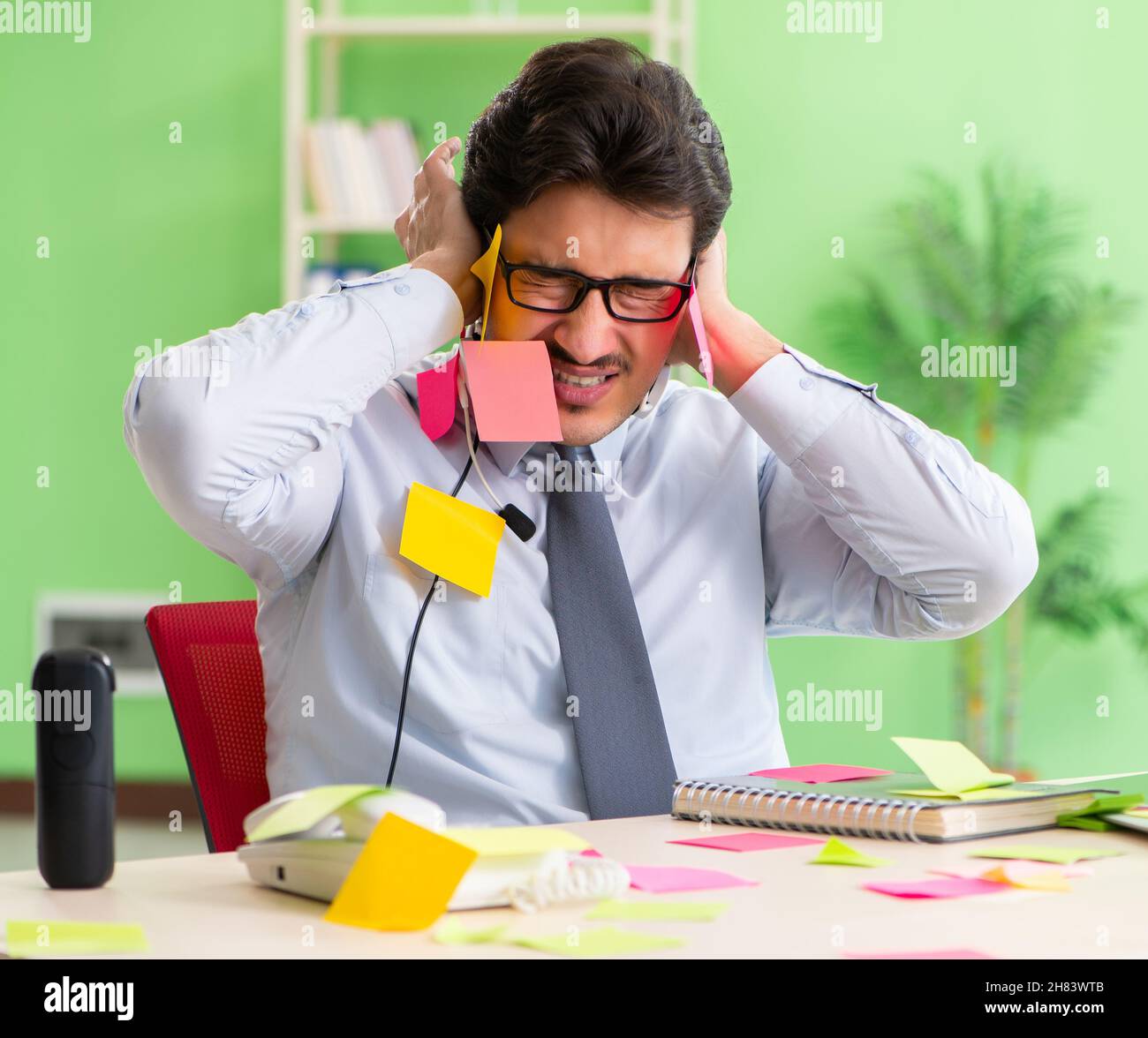 Young help desk operator working in office with many conflicting ...