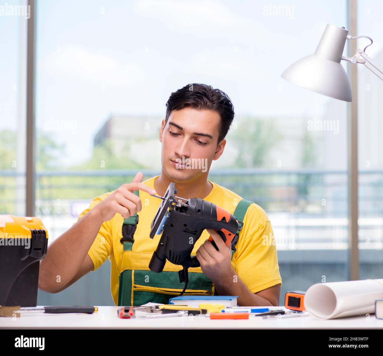The construction worker sitting at the desk Stock Photo - Alamy