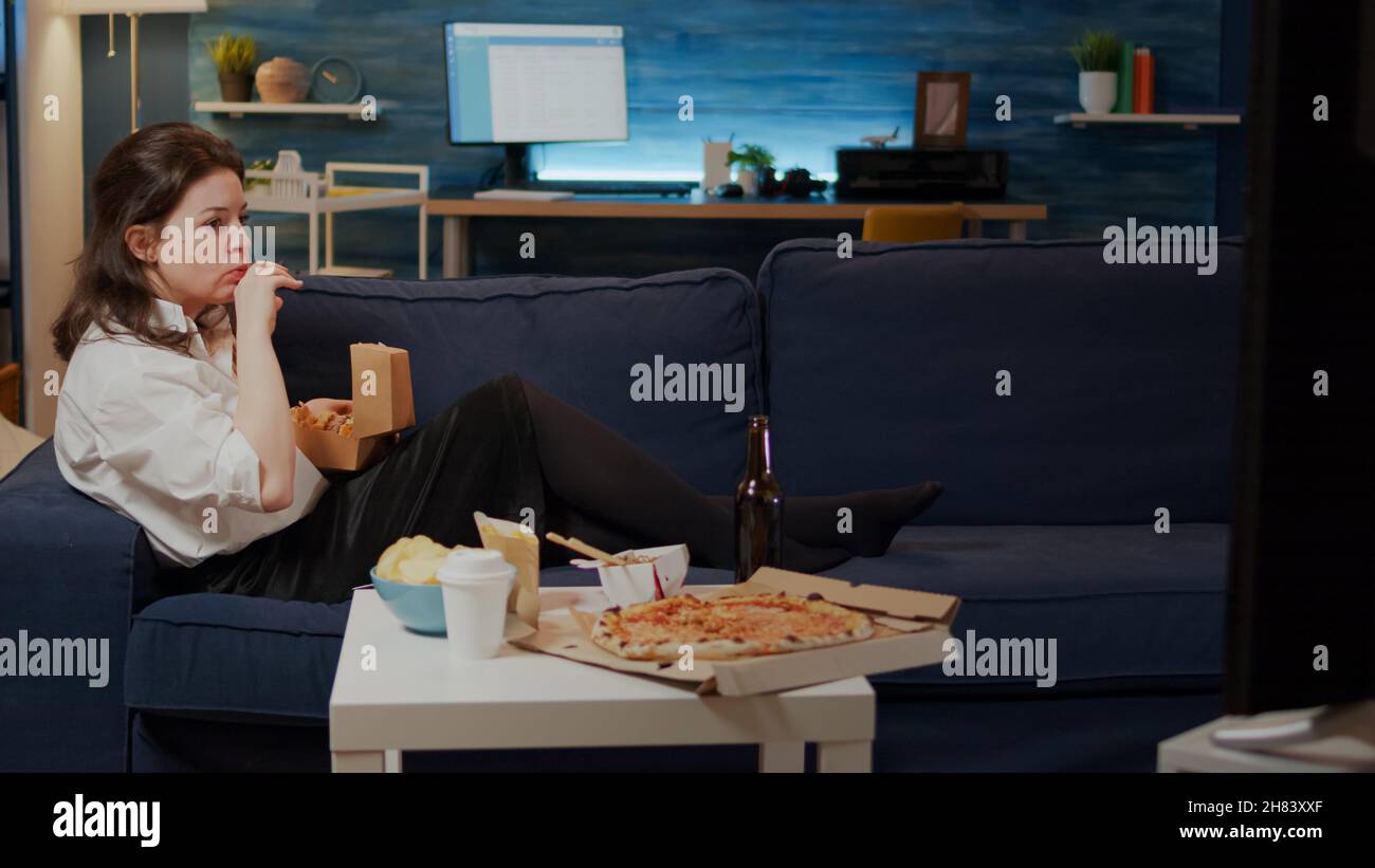 Woman laying on couch eating hi-res stock photography and images - Alamy