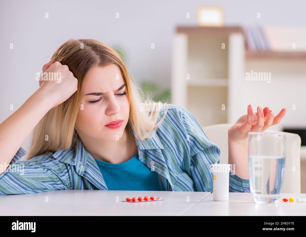 The woman taking pills to cope with pain Stock Photo - Alamy