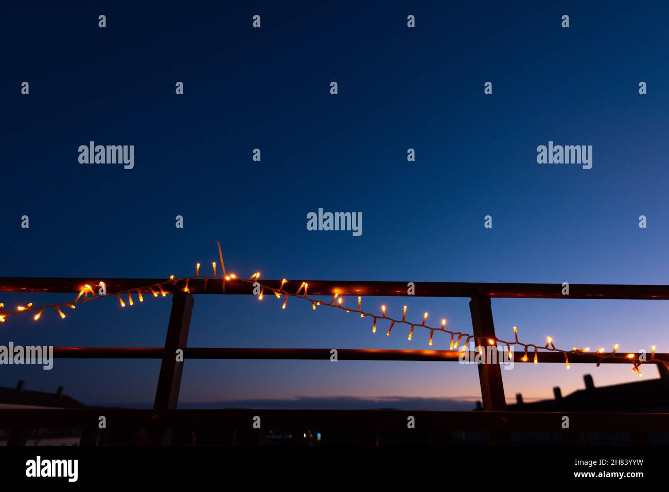 Christmas lights on the railings of a balcony at night Stock Photo - Alamy