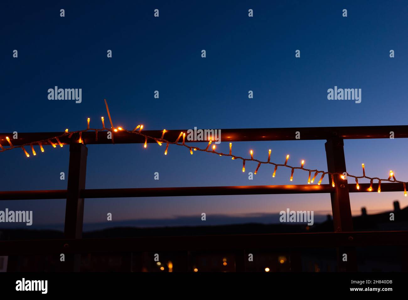 Christmas lights on the railings of a balcony at night Stock Photo - Alamy