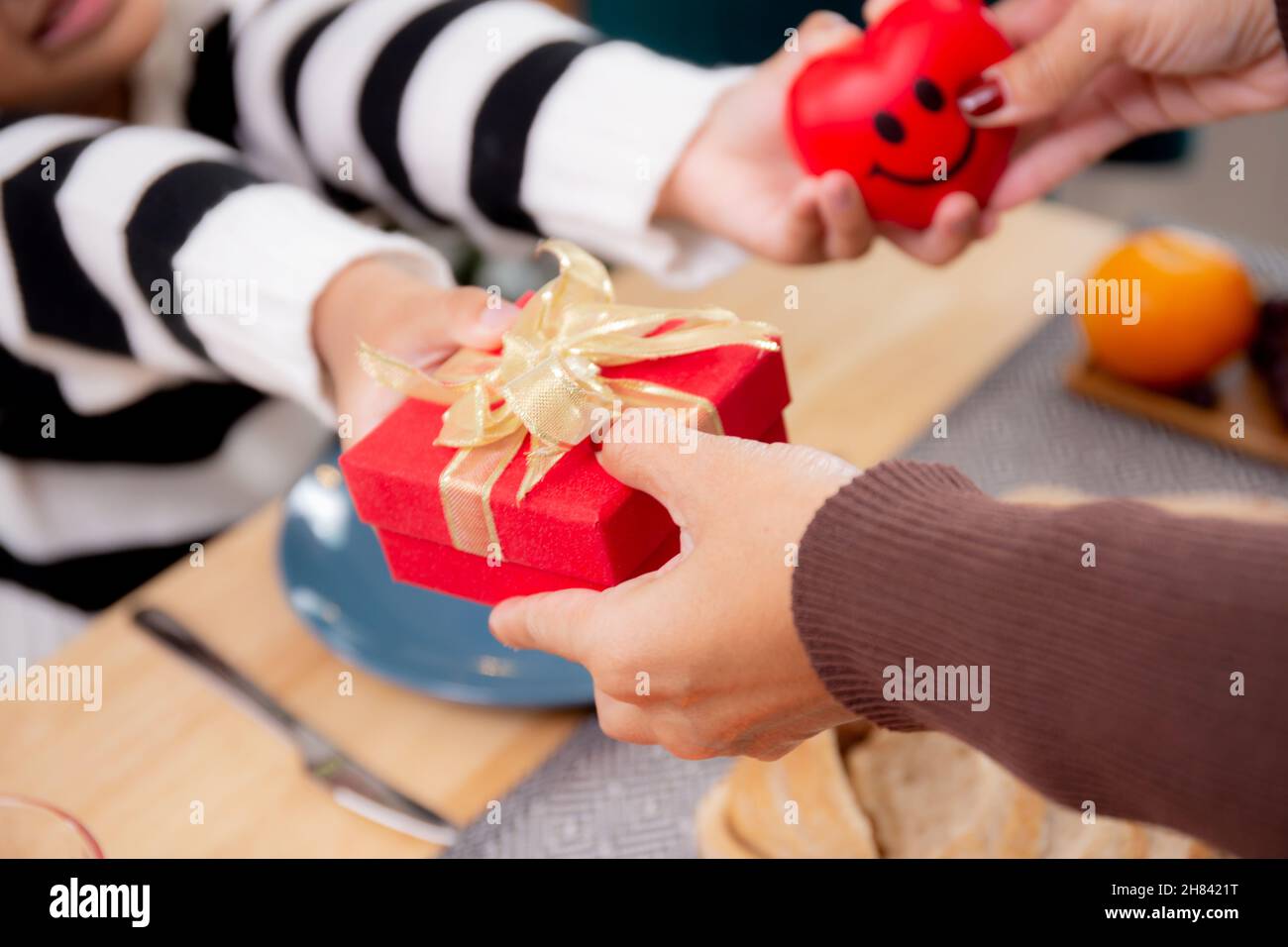Happy family with father and mother giving gift box with daughter ...