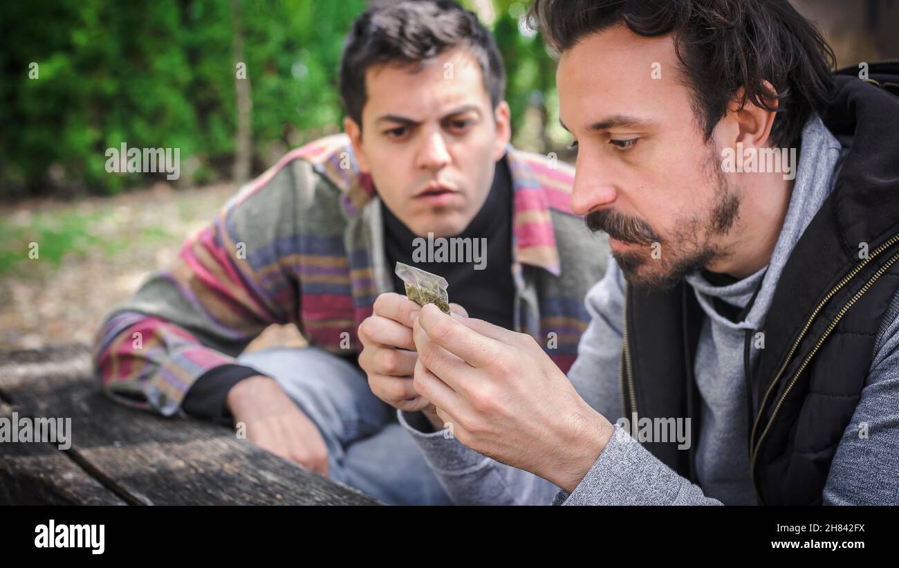 One friend shows the others marijuana weed packet ready to roll ...