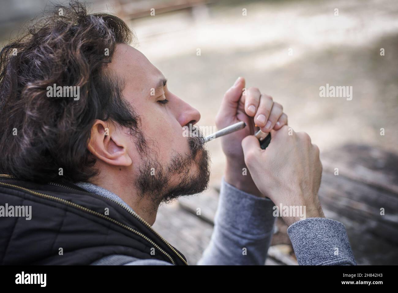 Man lighting up a joint a marihuana or hashish joint cigarette. Closeup ...