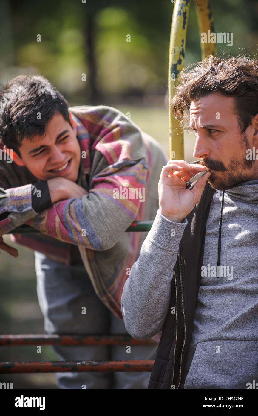 Two young friends smoking cannabis marijuana ganja or hashish joint in ...