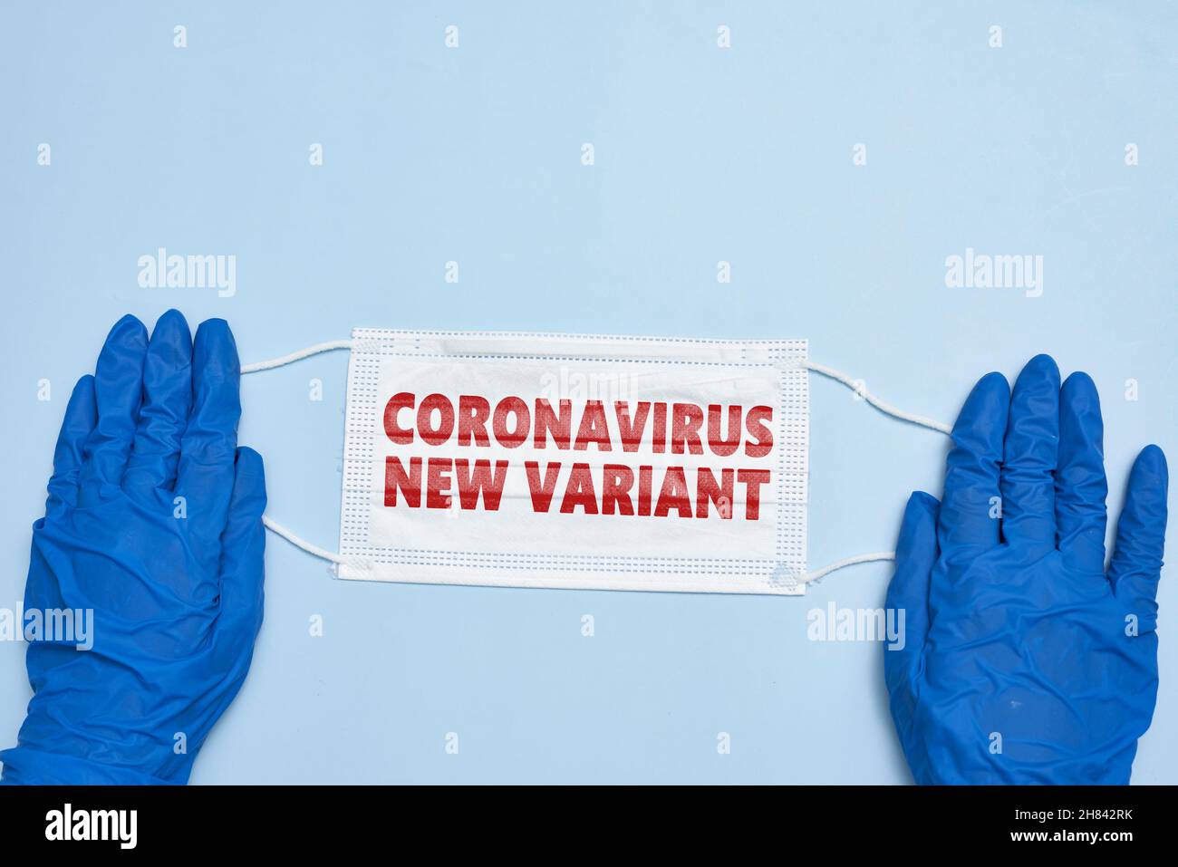 Female doctor holds a face mask with - Omicron variant text on it ...