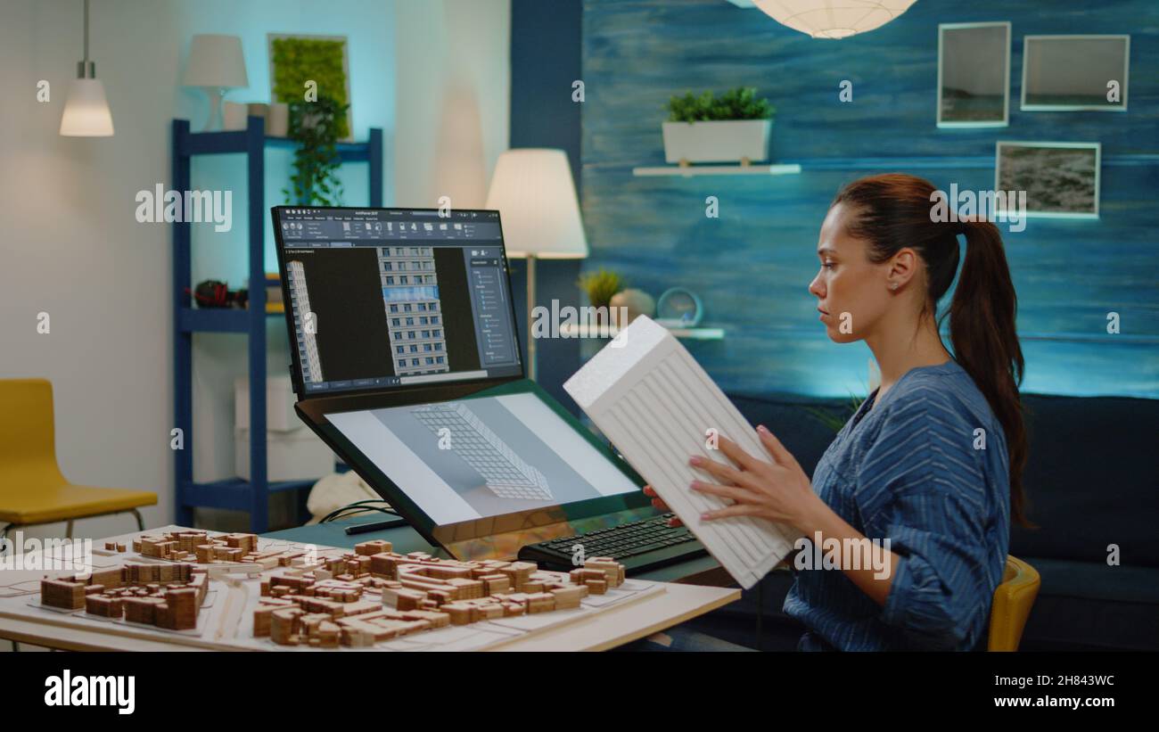 Architect Looking At Computer With Building Model For Construction Layout Project Woman