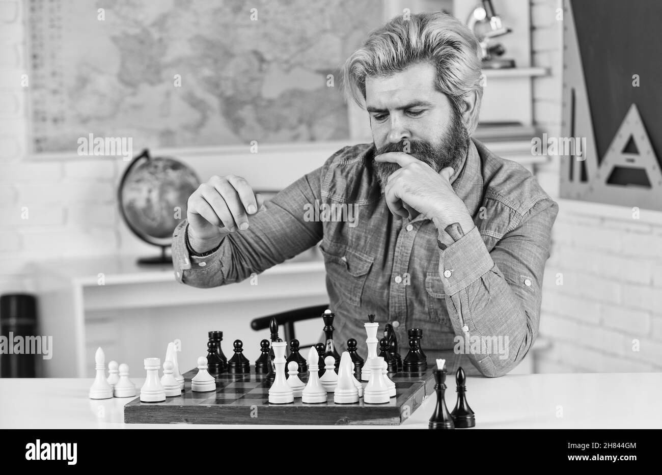 Figures on wooden chess board. Smart hipster man playing chess ...