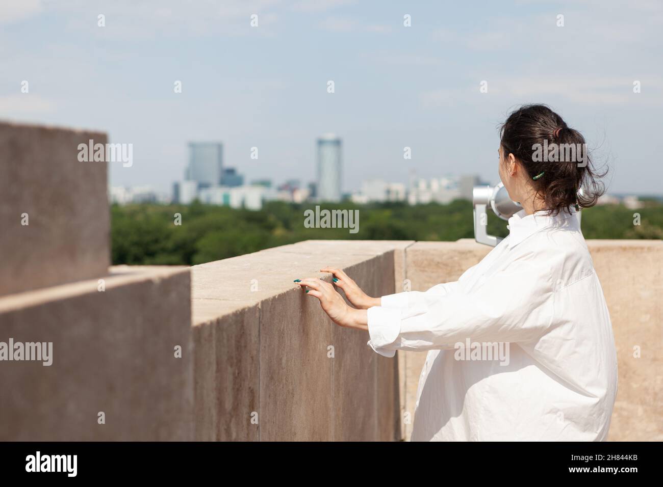Woman standing on tower rooftop enjoying summer vacation looking at ...
