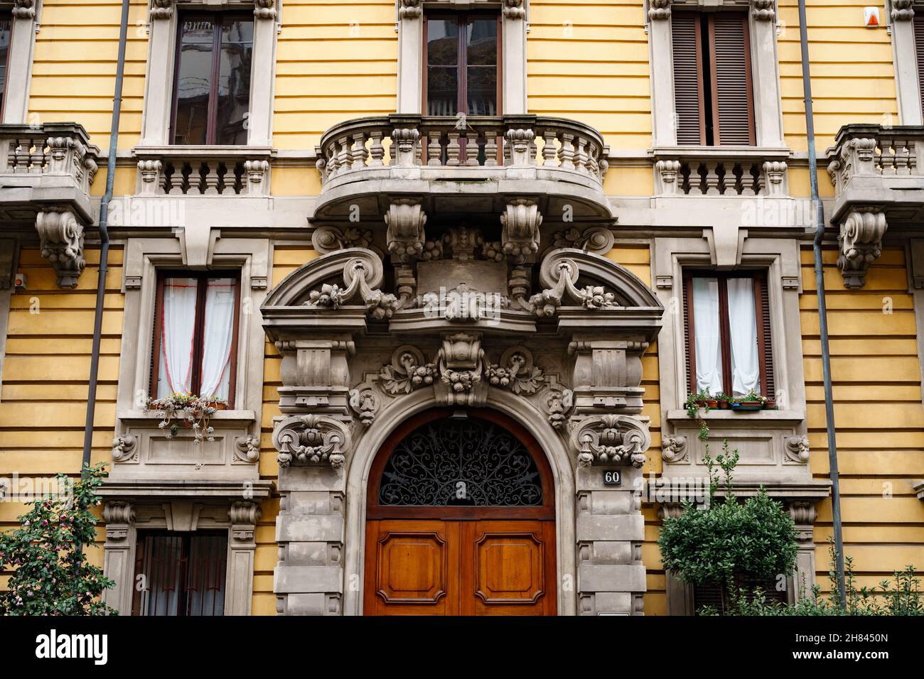Central entrance to the old building with stucco and balconies. Milan ...