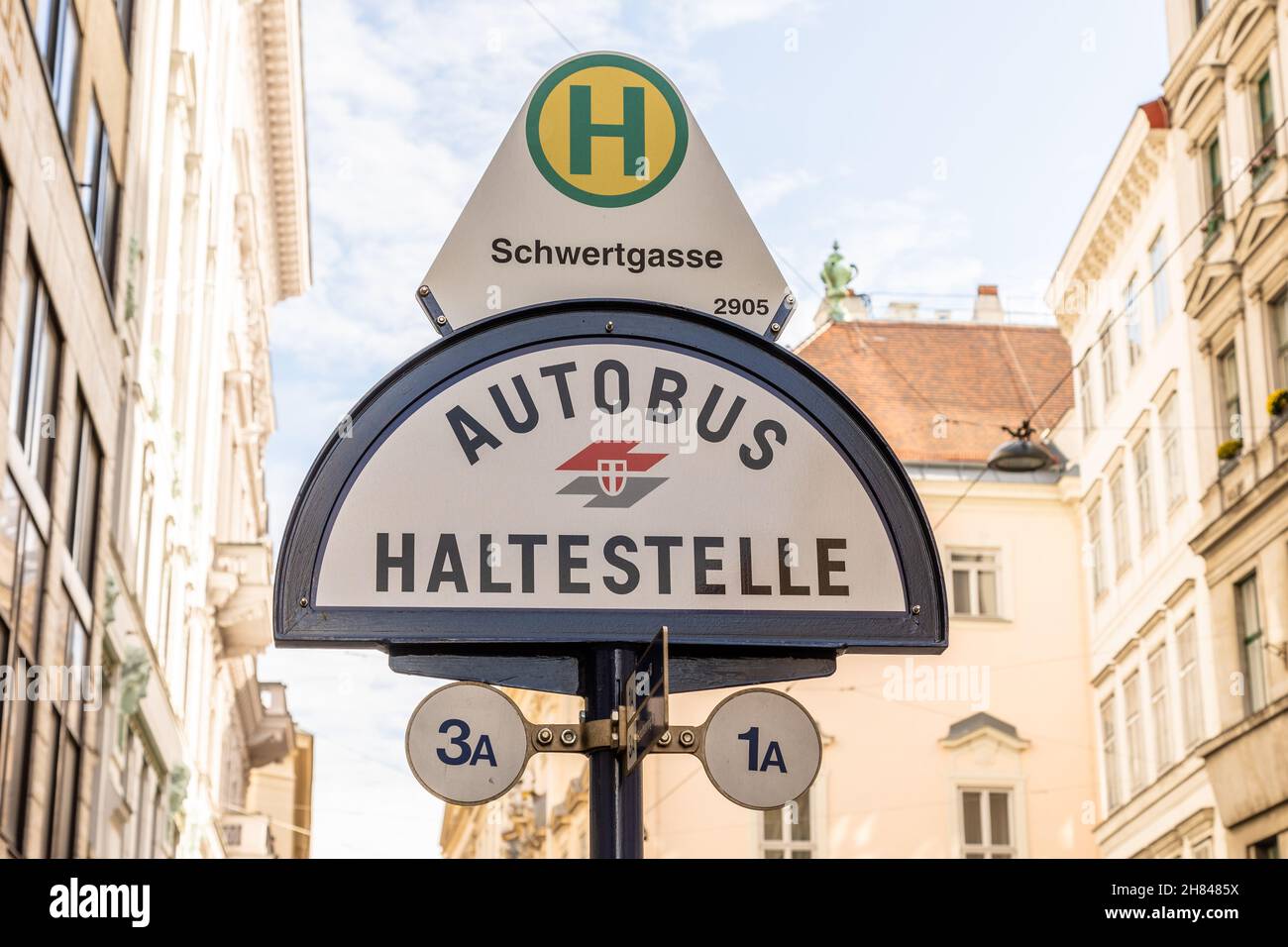 Semicircular bus stop with old historical buildings in the background ...
