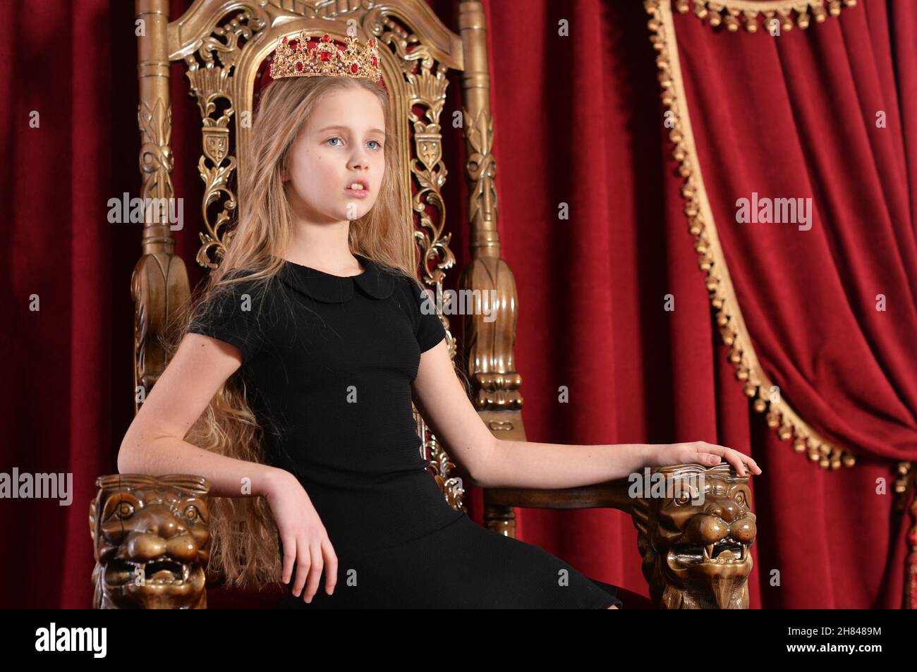 Happy girl princess posing on throne Stock Photo - Alamy