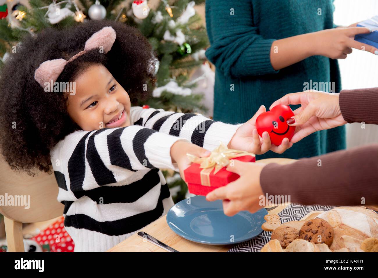 Happy family with father and mother giving gift box with daughter ...