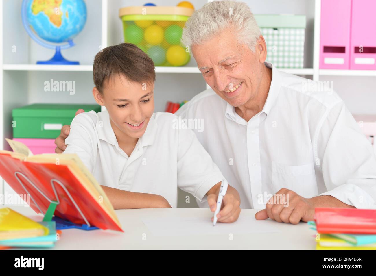 Grandfather with grandson doing homework at home Stock Photo - Alamy