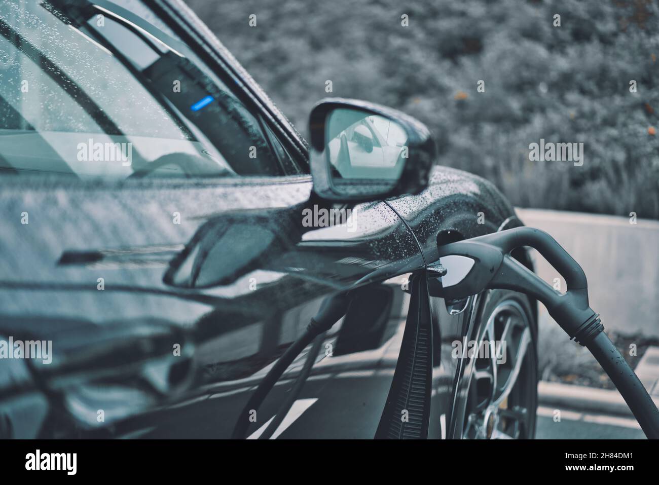 Side view of a black shiny modern car filling benzene with a background ...