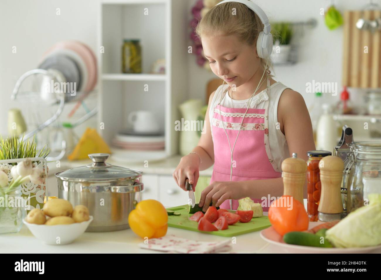 Cute happy girl coocking on kitchen and listening to music Stock Photo ...