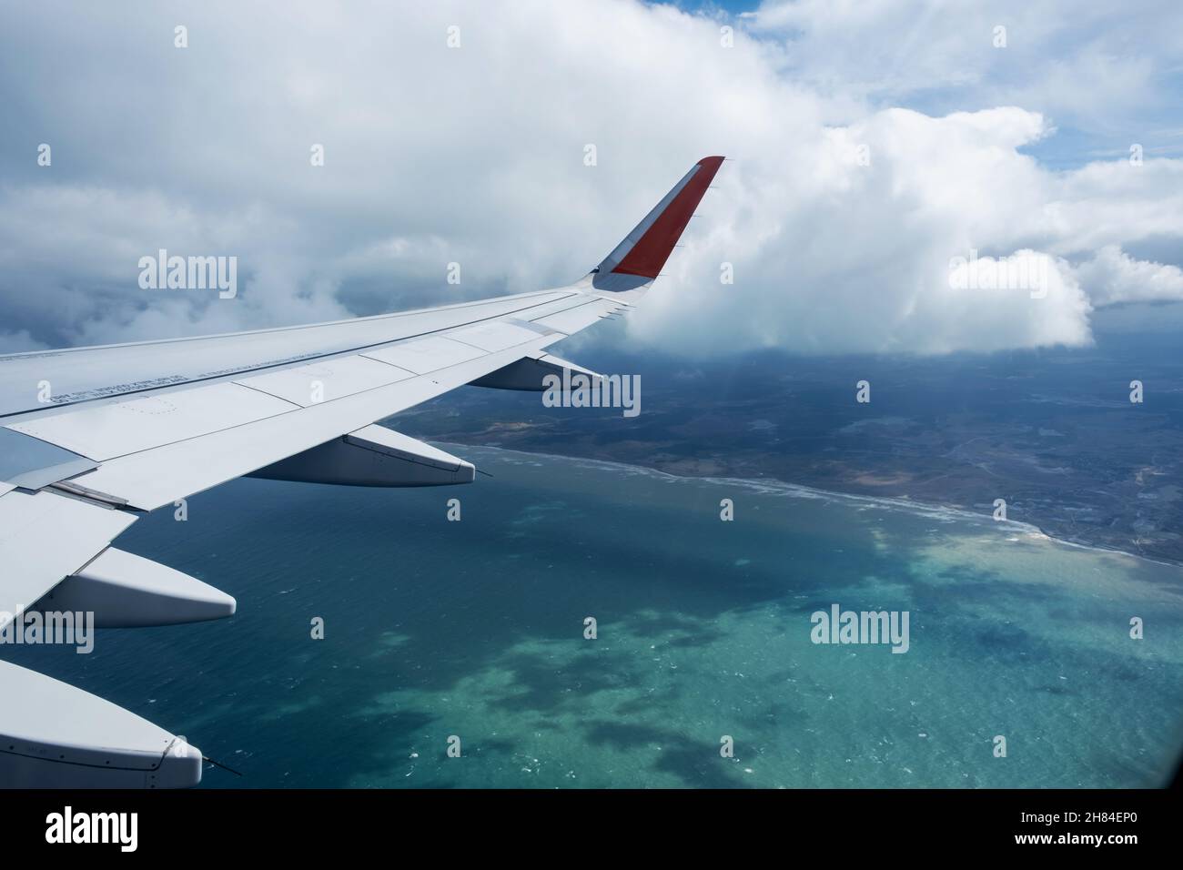 Classic image through aircraft window onto wing. Flight view over sea ...