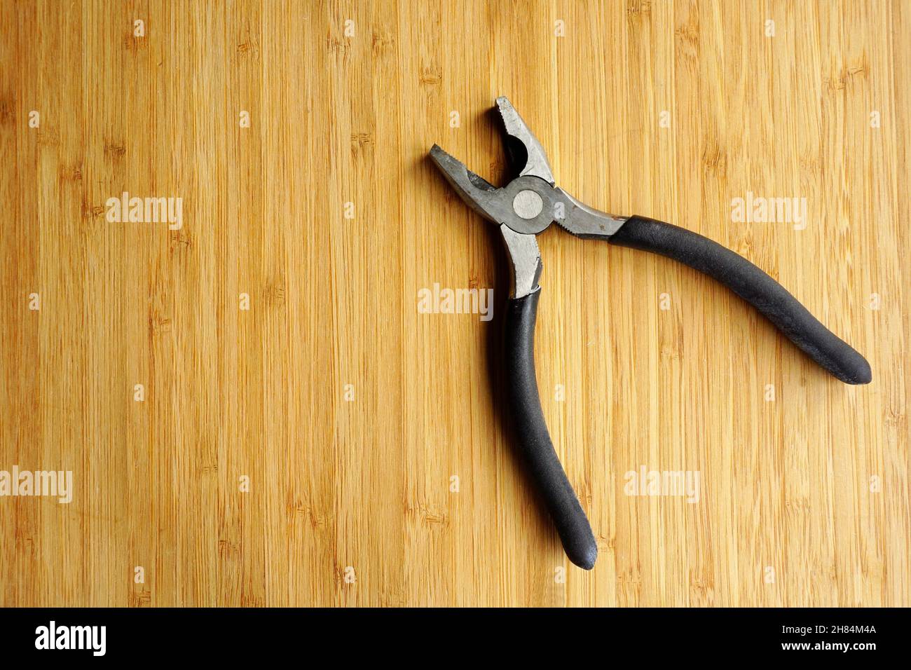 Combination pliers on wooden background with copy space Stock Photo - Alamy