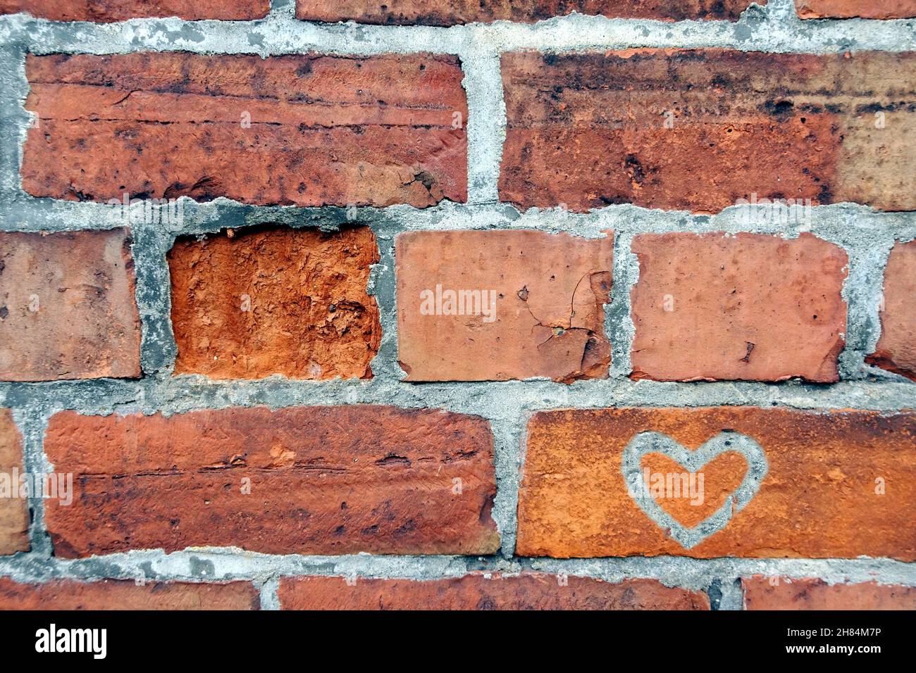 Red brick wall background with small heart shape Stock Photo - Alamy