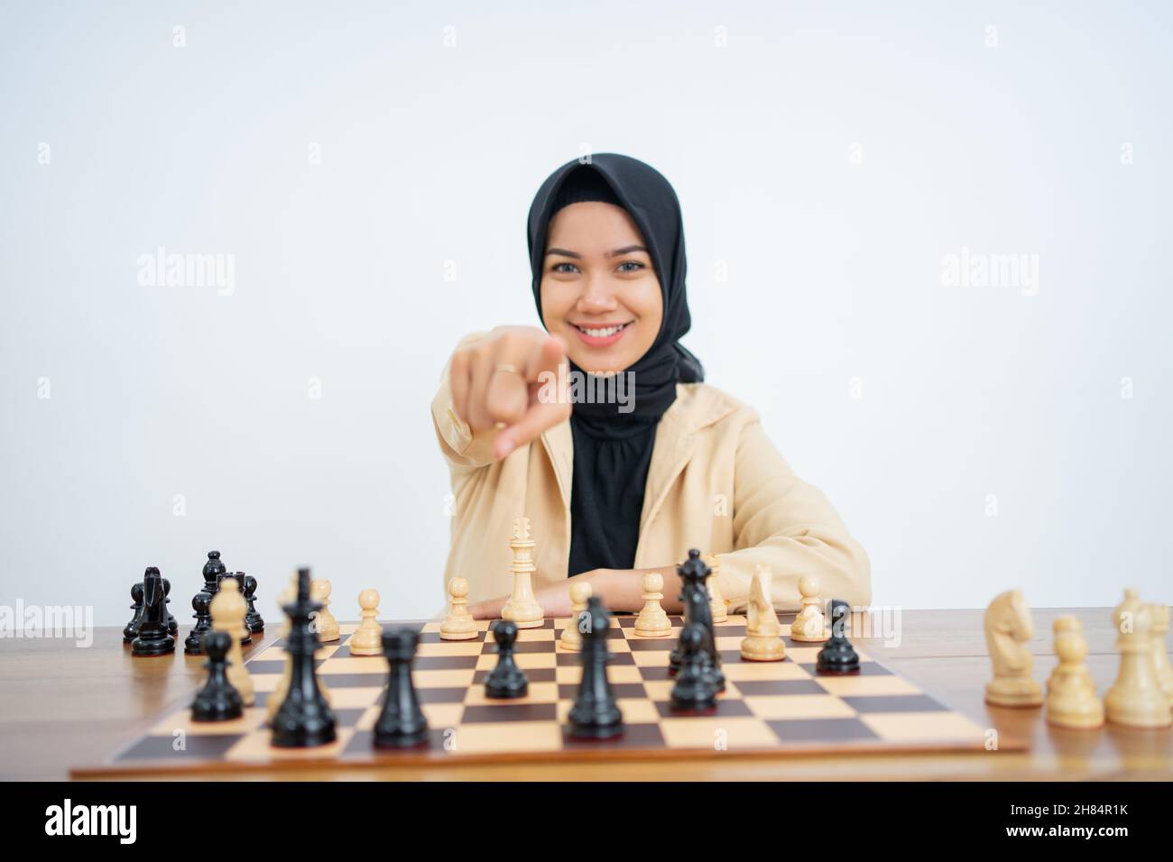 Hijab woman with finger pointing while sitting playing chess Stock ...
