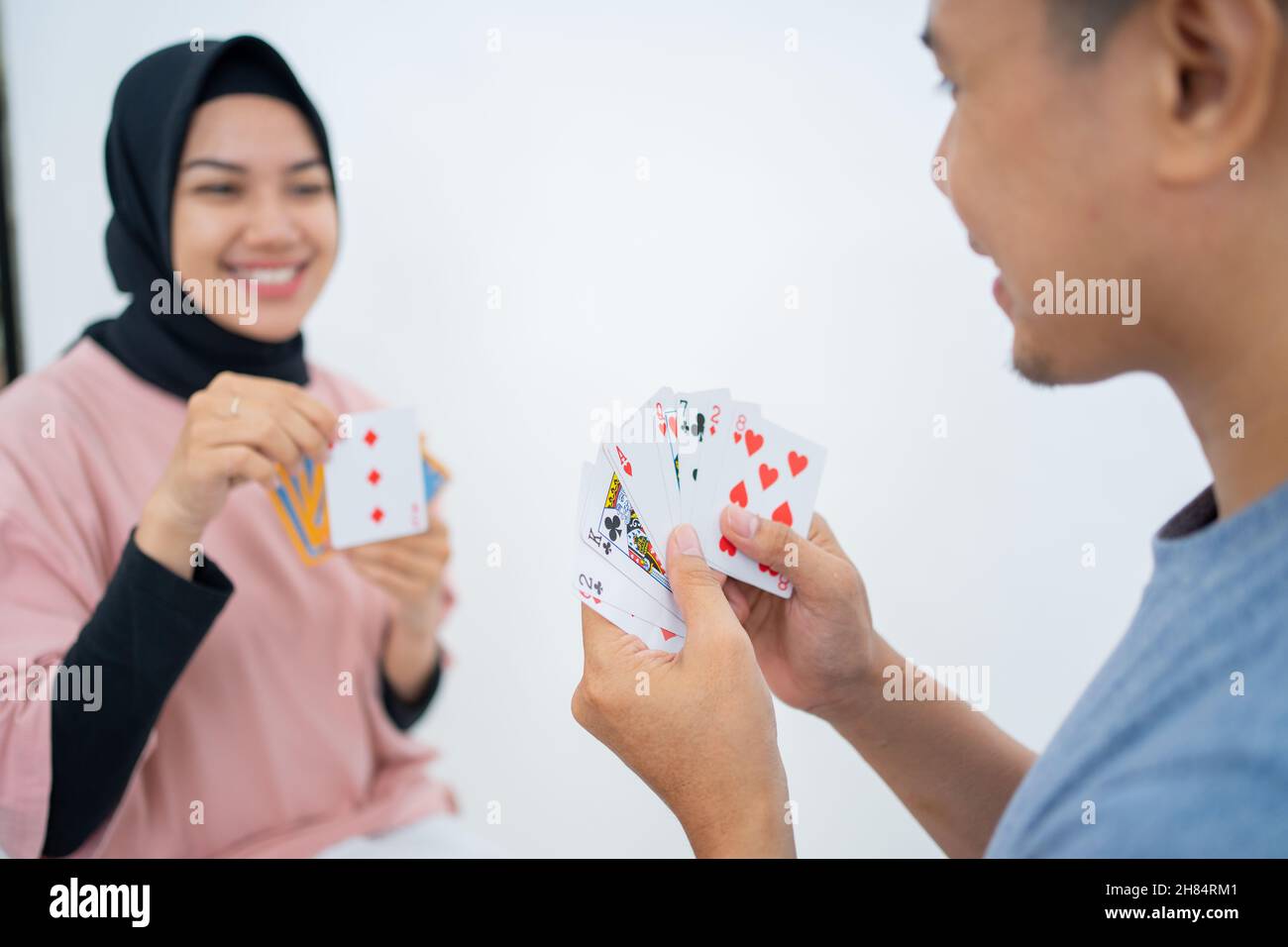 Several cards held by man while playing cards with friends Stock Photo ...