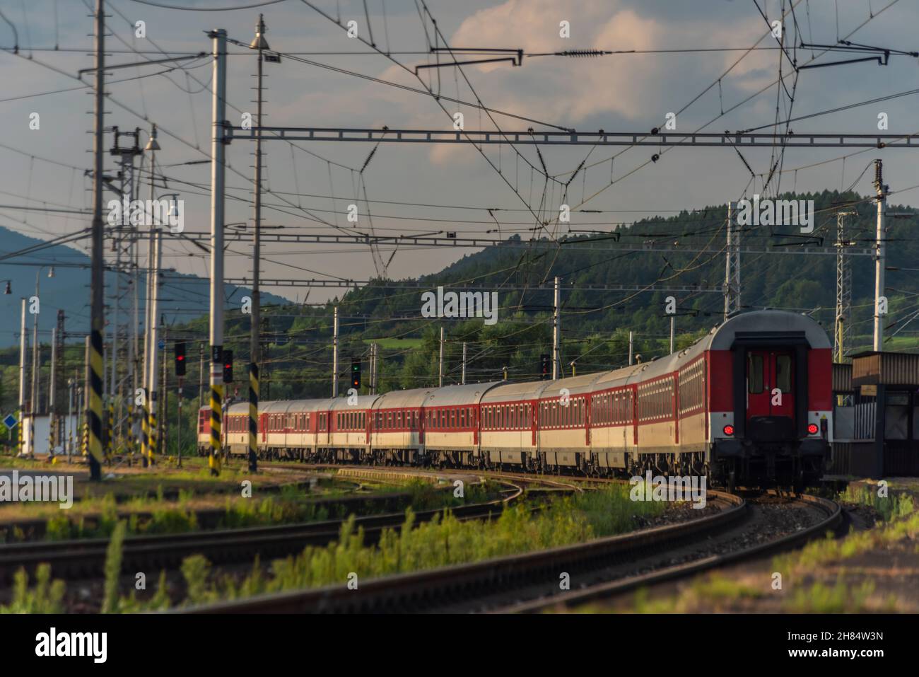 Passenger train with red electric locomotive and passenger red coaches ...