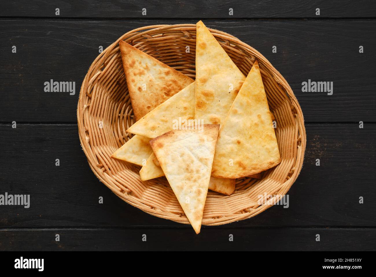 Top view of tortilla cut on triangular slices in wicker backet on a ...