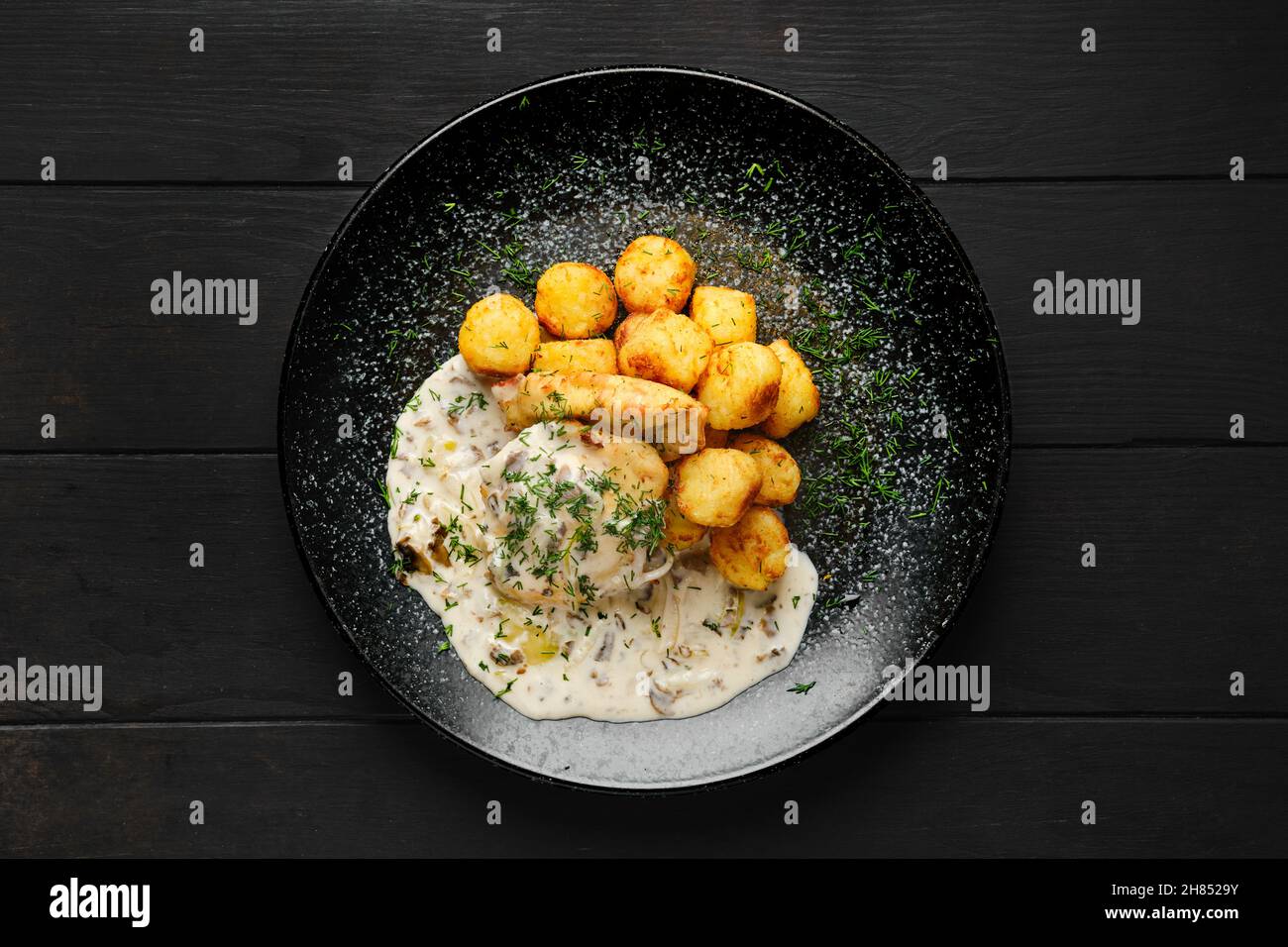 Top view of fried zander fillet with mushroom sauce and potato balls on ...