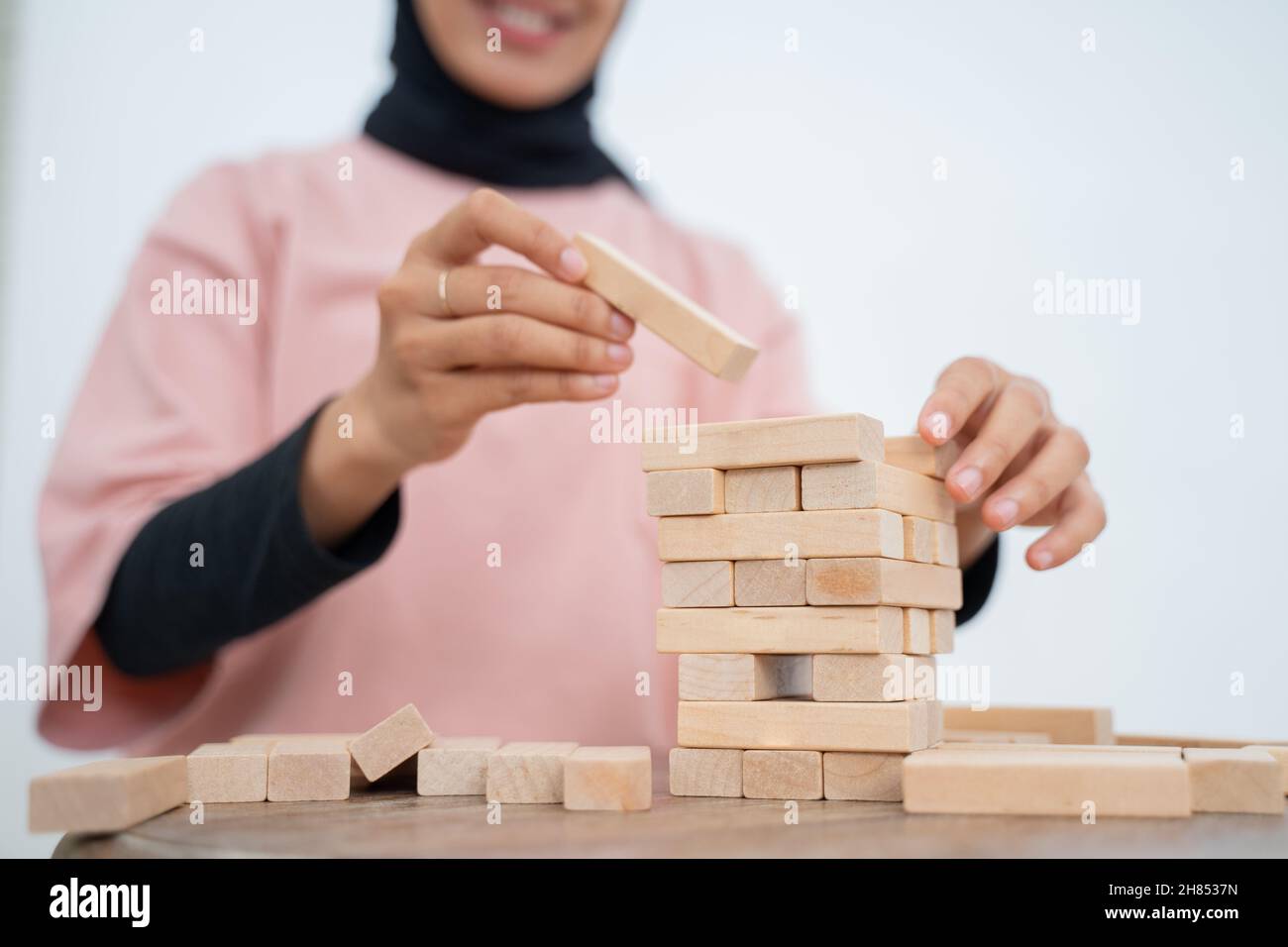 Female hands stacking blocks while playing wooden block tower Stock ...
