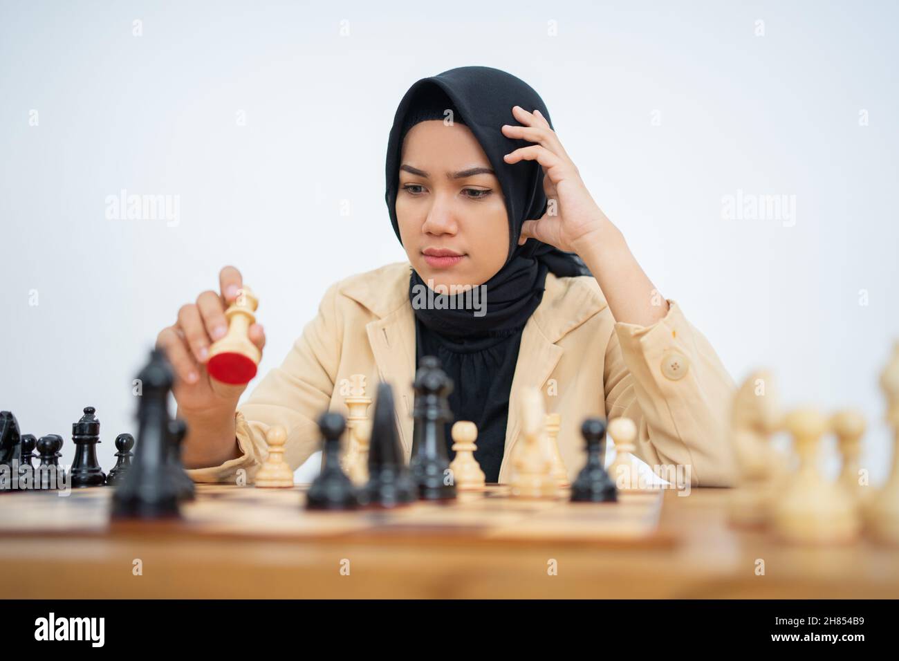 Muslim woman thinking steps while holding chess pieces Stock Photo - Alamy