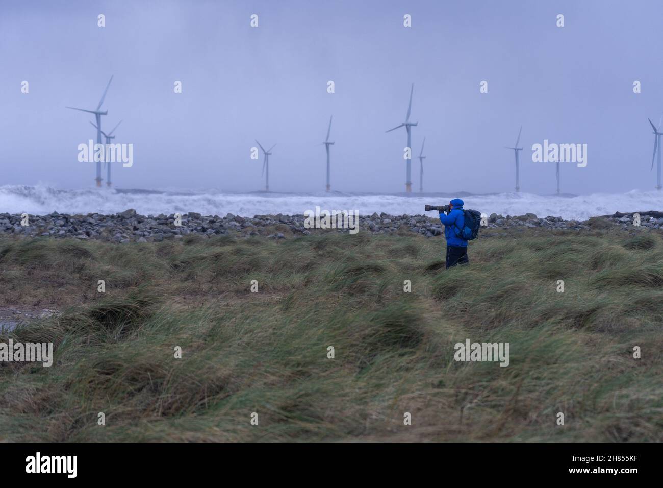 Redcar, UK. 27th Nov, 2021. A photographer takes photos as huge waves ...