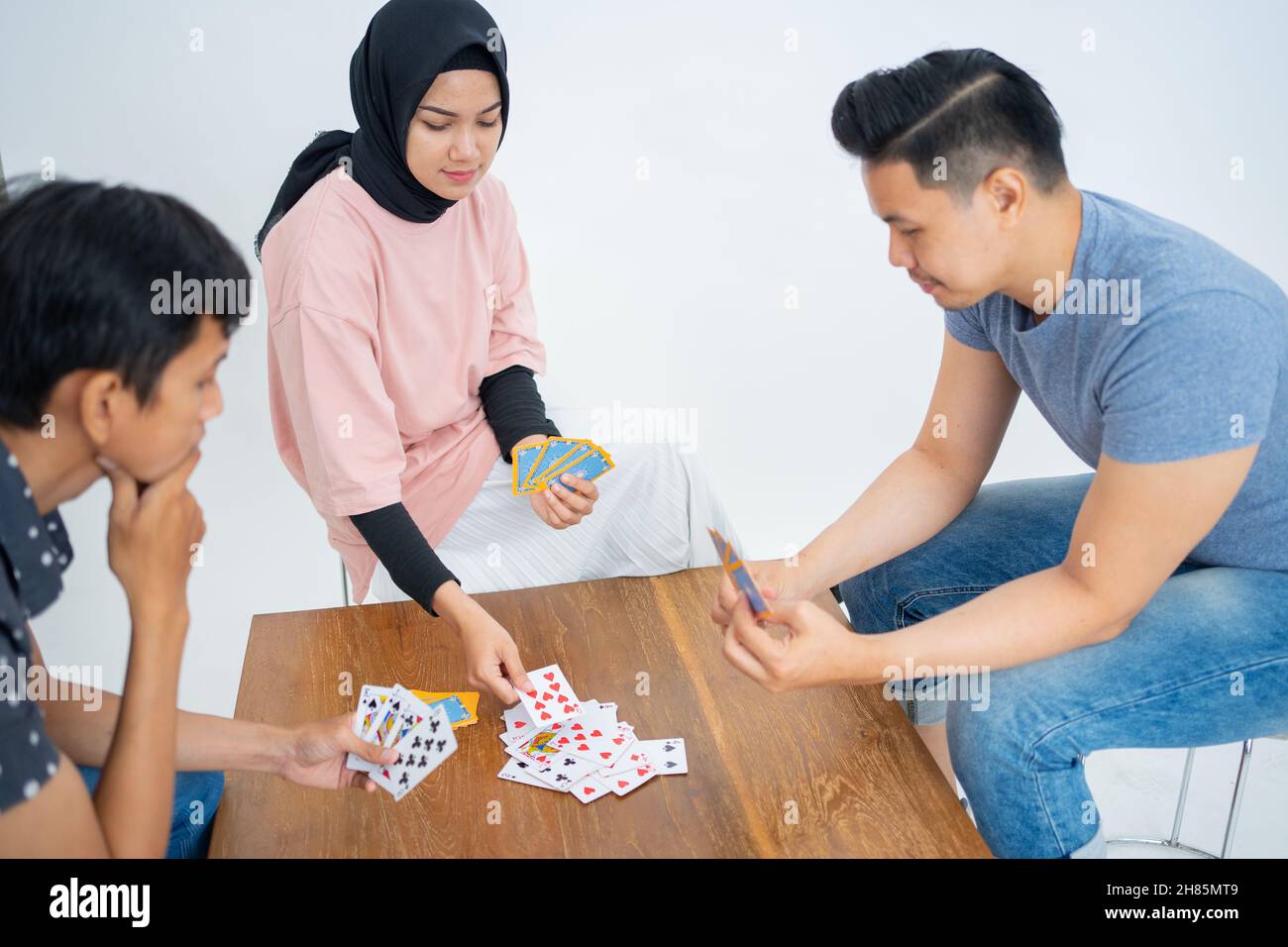 Woman putting cards on table while playing cards with friends Stock ...