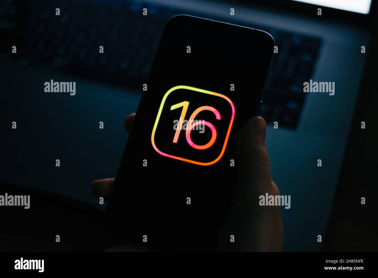 iPhone 13 pro with iOS 16 logo on the screen close up, new operating ...