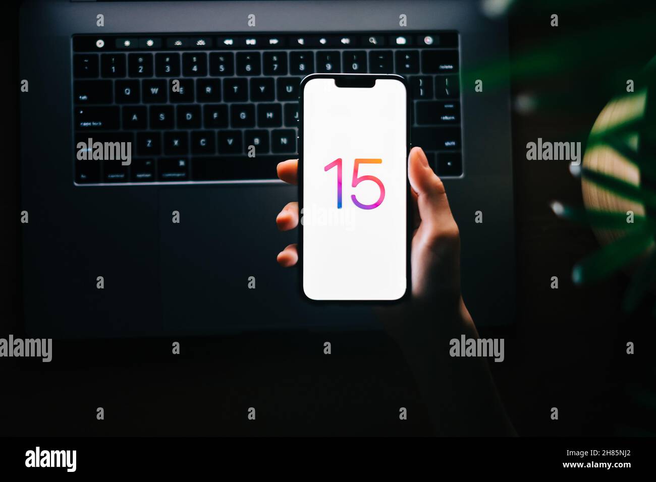 iPhone 13 pro with iOS 15 logo on the screen close up, new operating ...