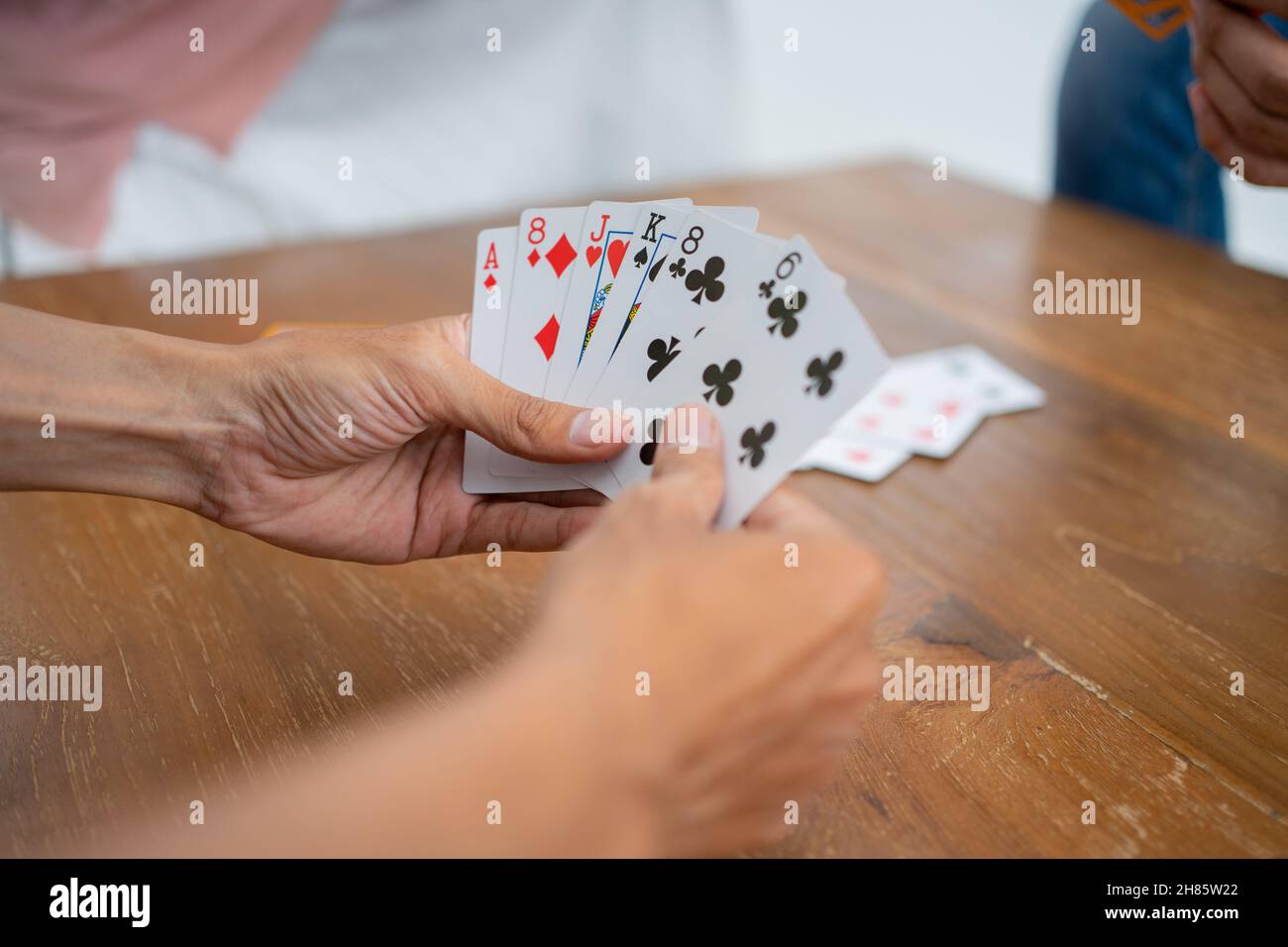 Two hands holding cards while playing cards togethe Stock Photo - Alamy