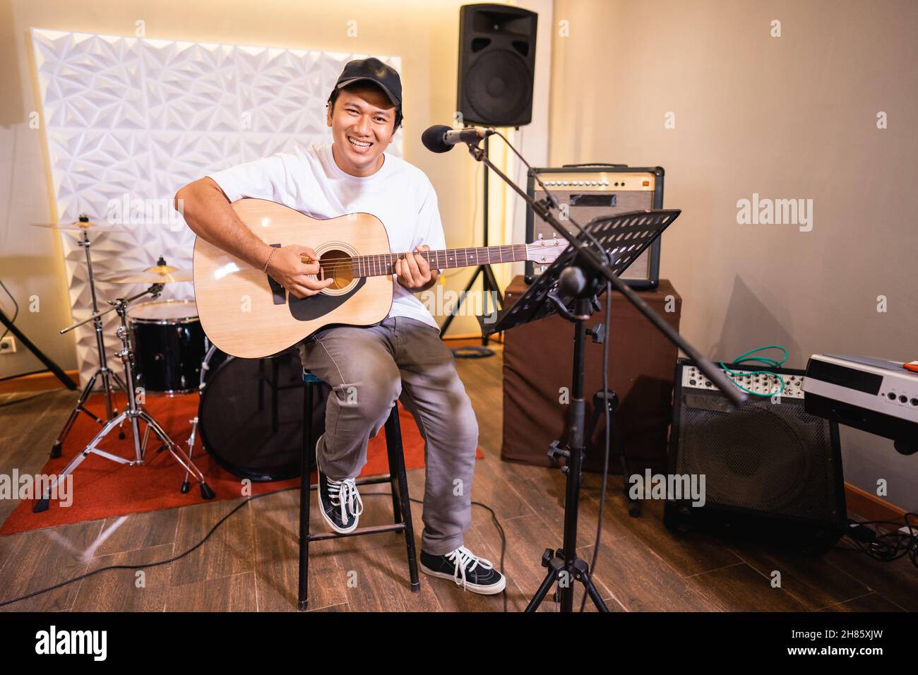 a vocalist sings while playing an acoustic guitar with musical ...