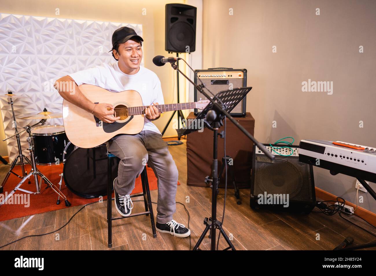 a vocalist sings while playing an acoustic guitar with musical ...