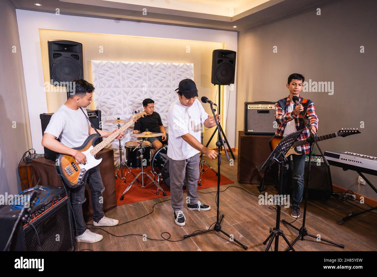 four boys checking musical instruments before starting to practice ...