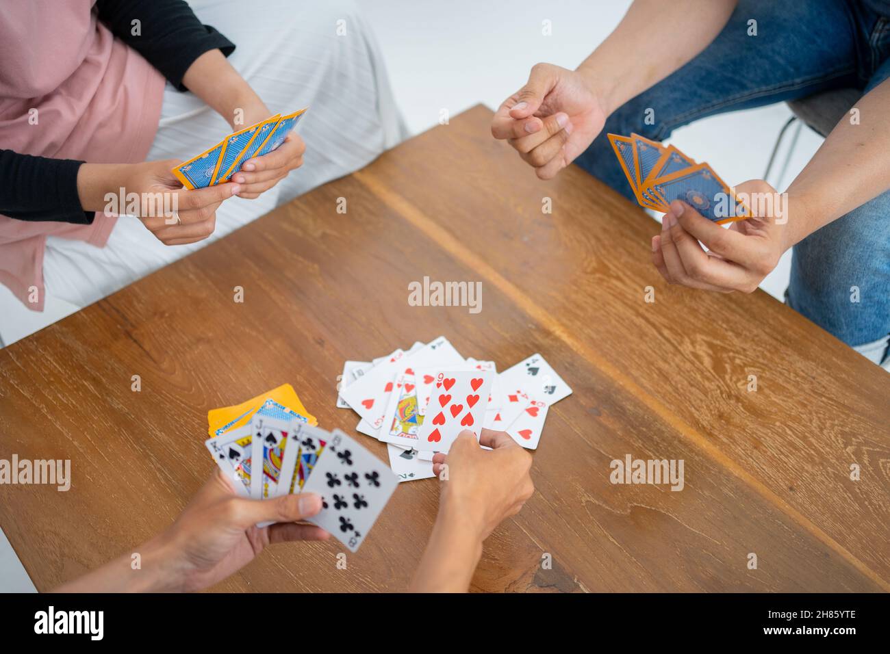 Hands issuing cards to table while playing cards together Stock Photo ...